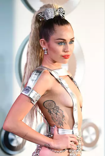 Miley Cyrus na may etnikong tattoo sa gilid