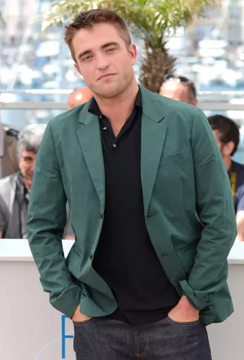 Robert Pattinson yn sefyll yng Ngŵyl Ffilm Cannes 2014.