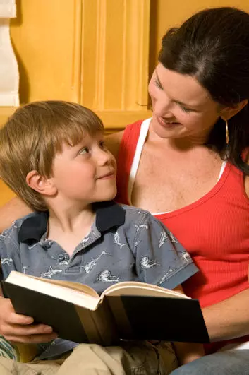 Boy reading with his mother